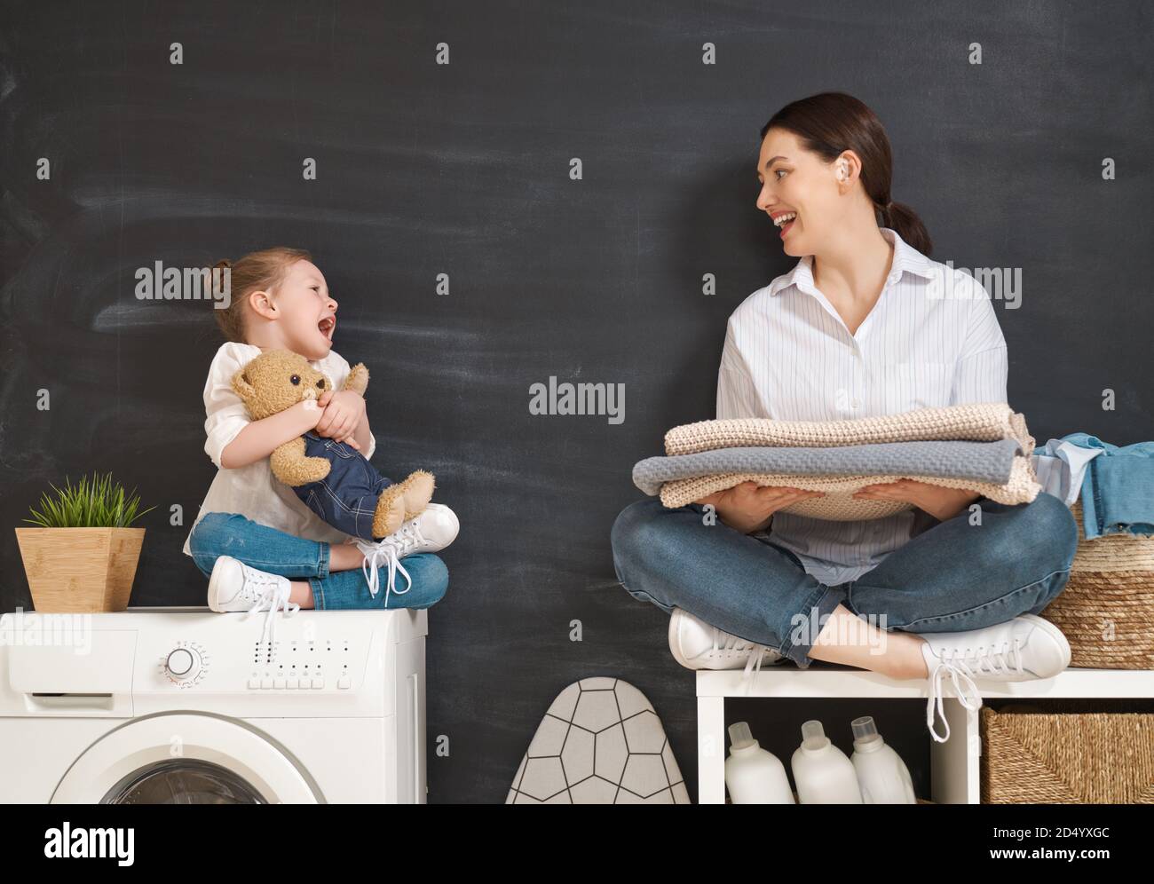 Beautiful young woman and child girl little helper are having fun and ...