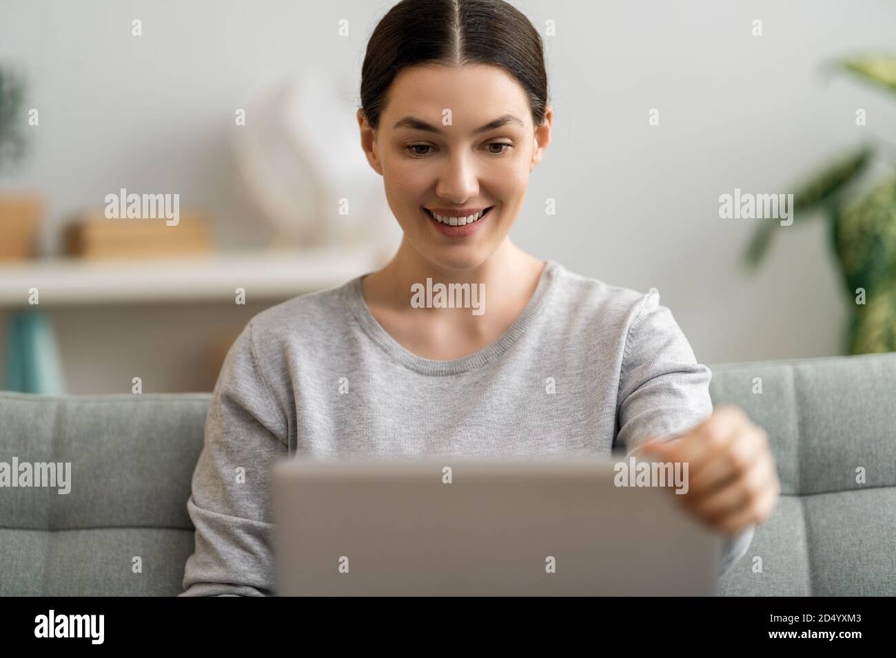 Young woman is using laptop pc for remote conversation with friends ...
