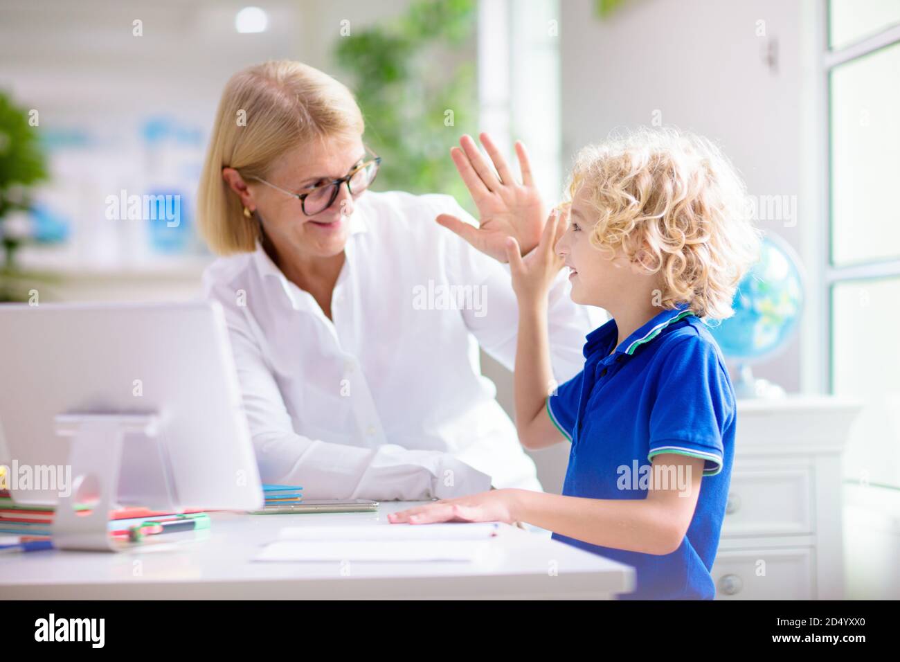 Online remote learning. School kids with computer having video ...