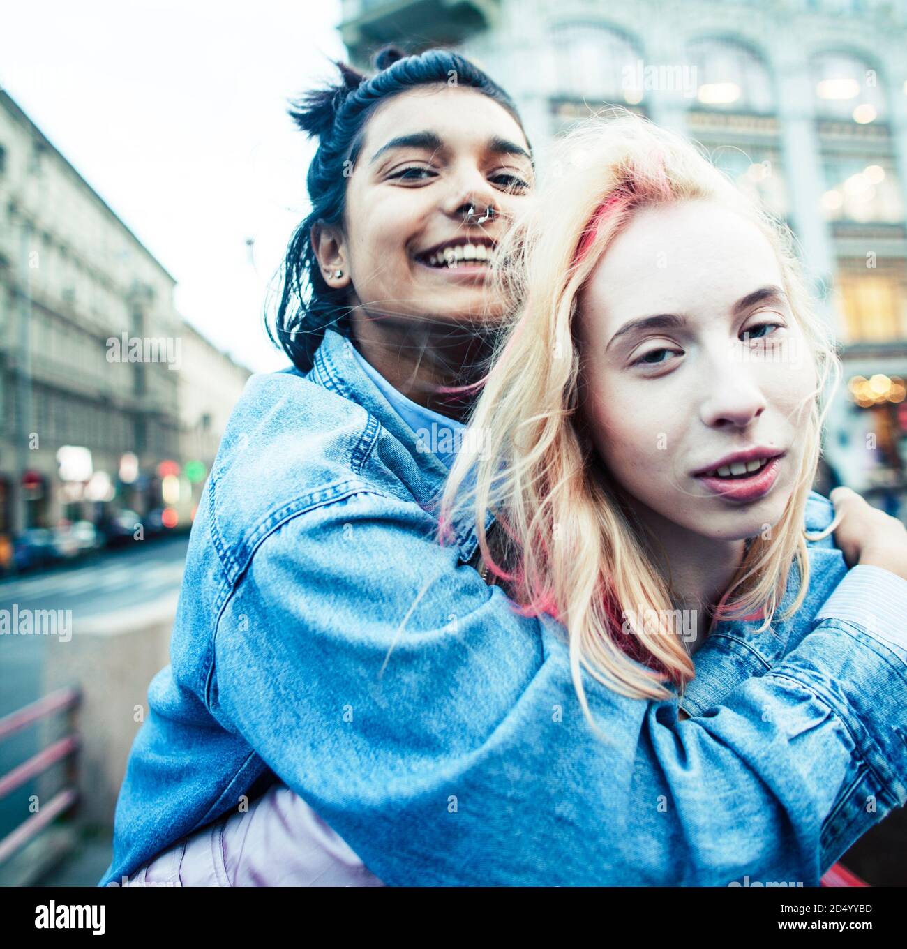 Two teenage girls infront of university building smiling, having fun ...