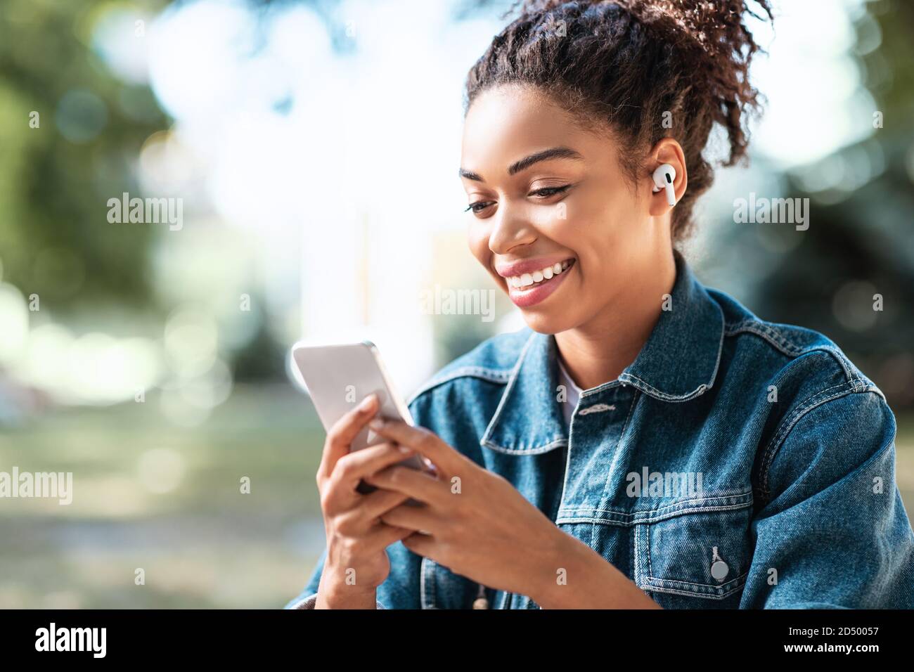 Happy Black Lady Using Smartphone Texting Sitting In Park Outdoor Stock ...