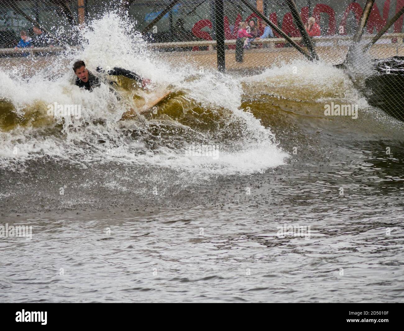 Surfer falls in a wall of spray at Surf Snowdonia, Wales Stock Photo ...