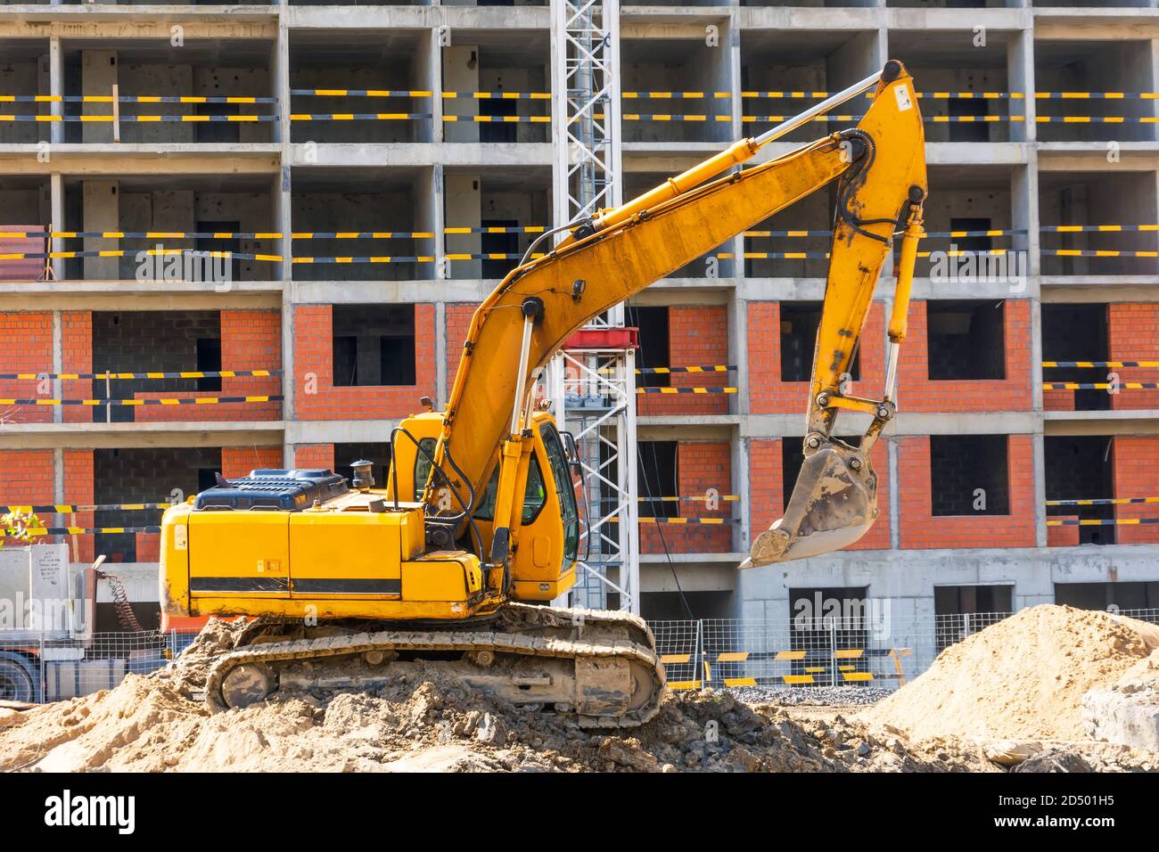 Excavators with raised buckets on the background of a multi-story ...