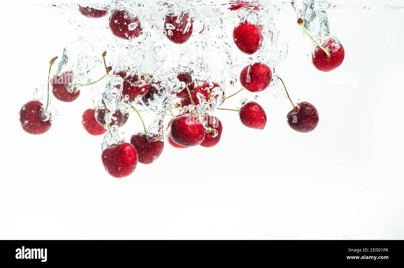 Red cherries splashing into crystal clear water with air bubbles Stock ...