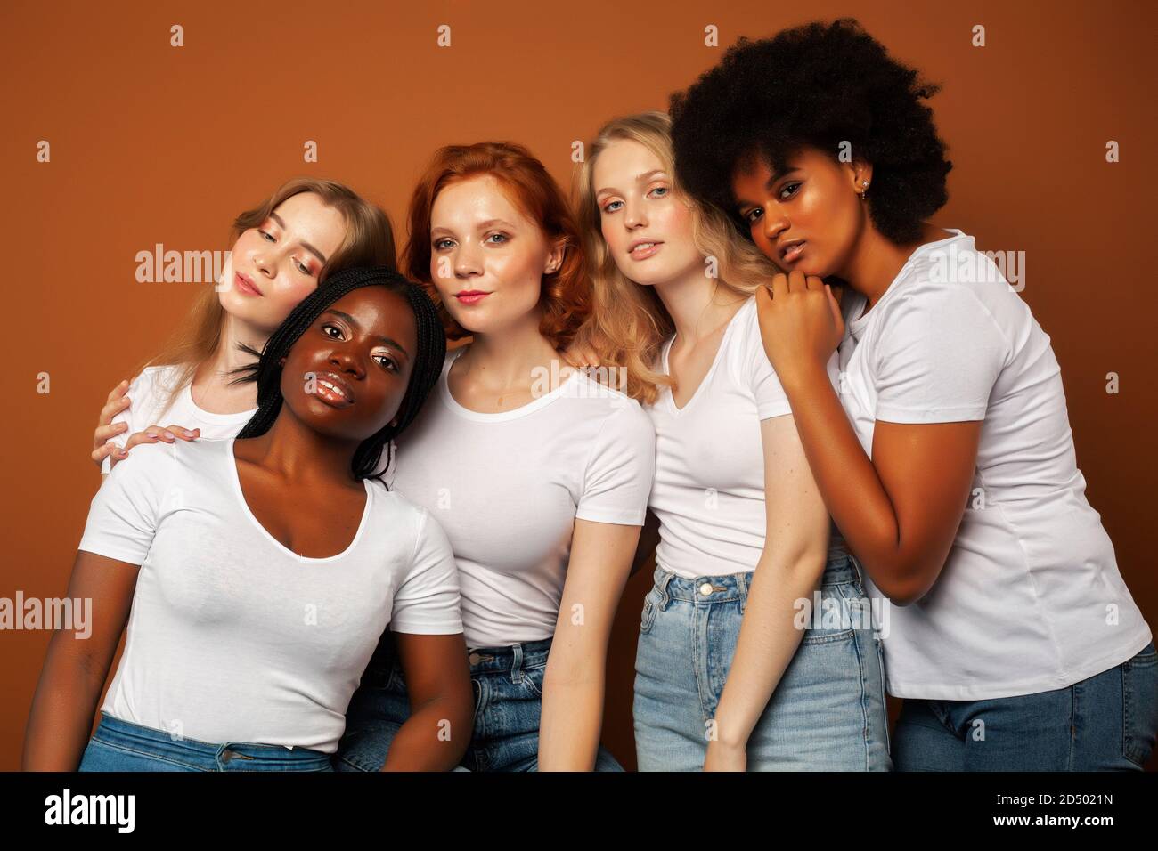 young pretty asian, caucasian, afro woman posing cheerful together on brown background ...
