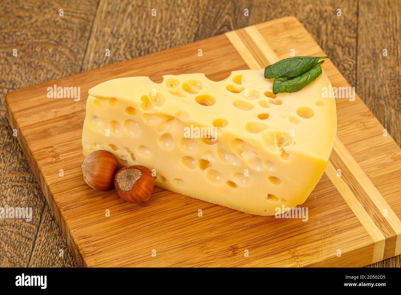 Maasdam cheese - dairy yellow triangle with holes Stock Photo - Alamy