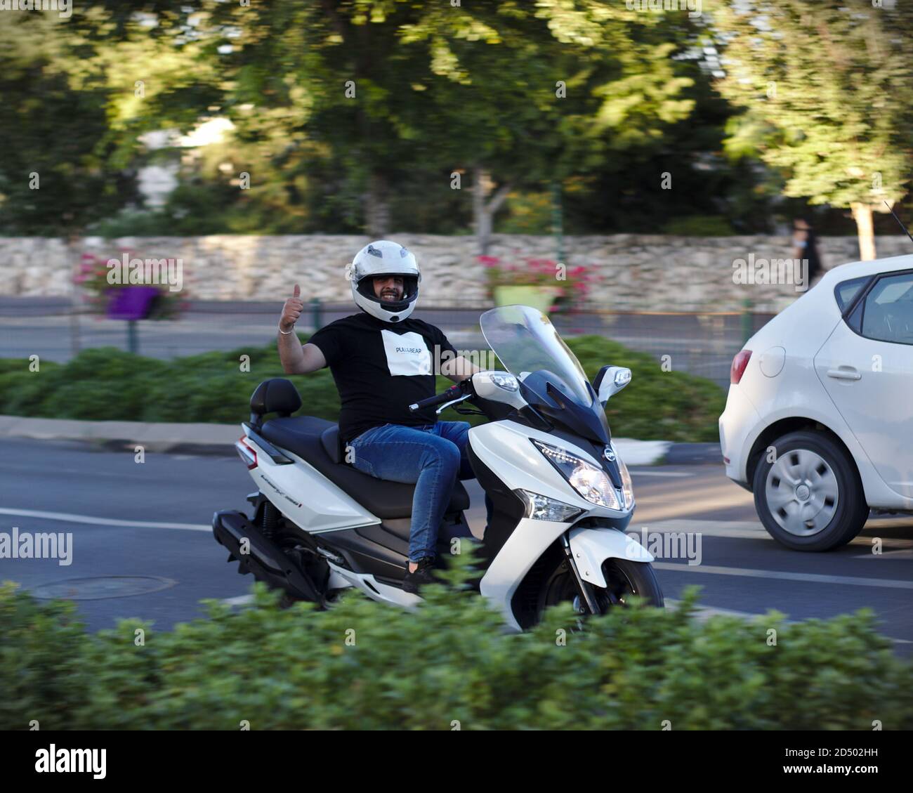 A happy scooter rider giving a thumbs-up Stock Photo - Alamy