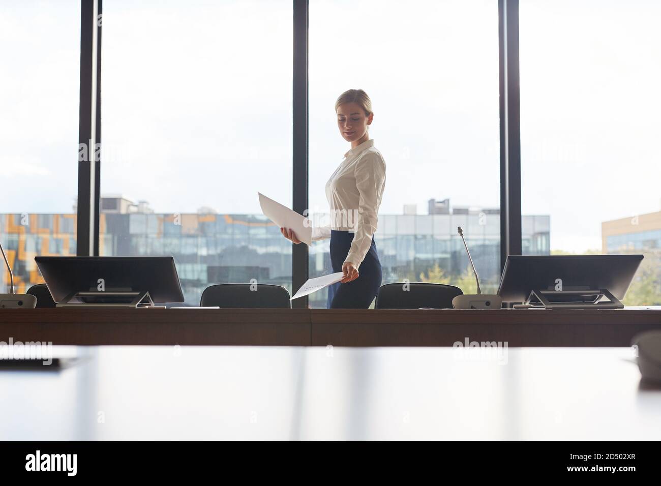 Wide Angle Portrait Of Elegant Female Secretary Laying Out Documents On