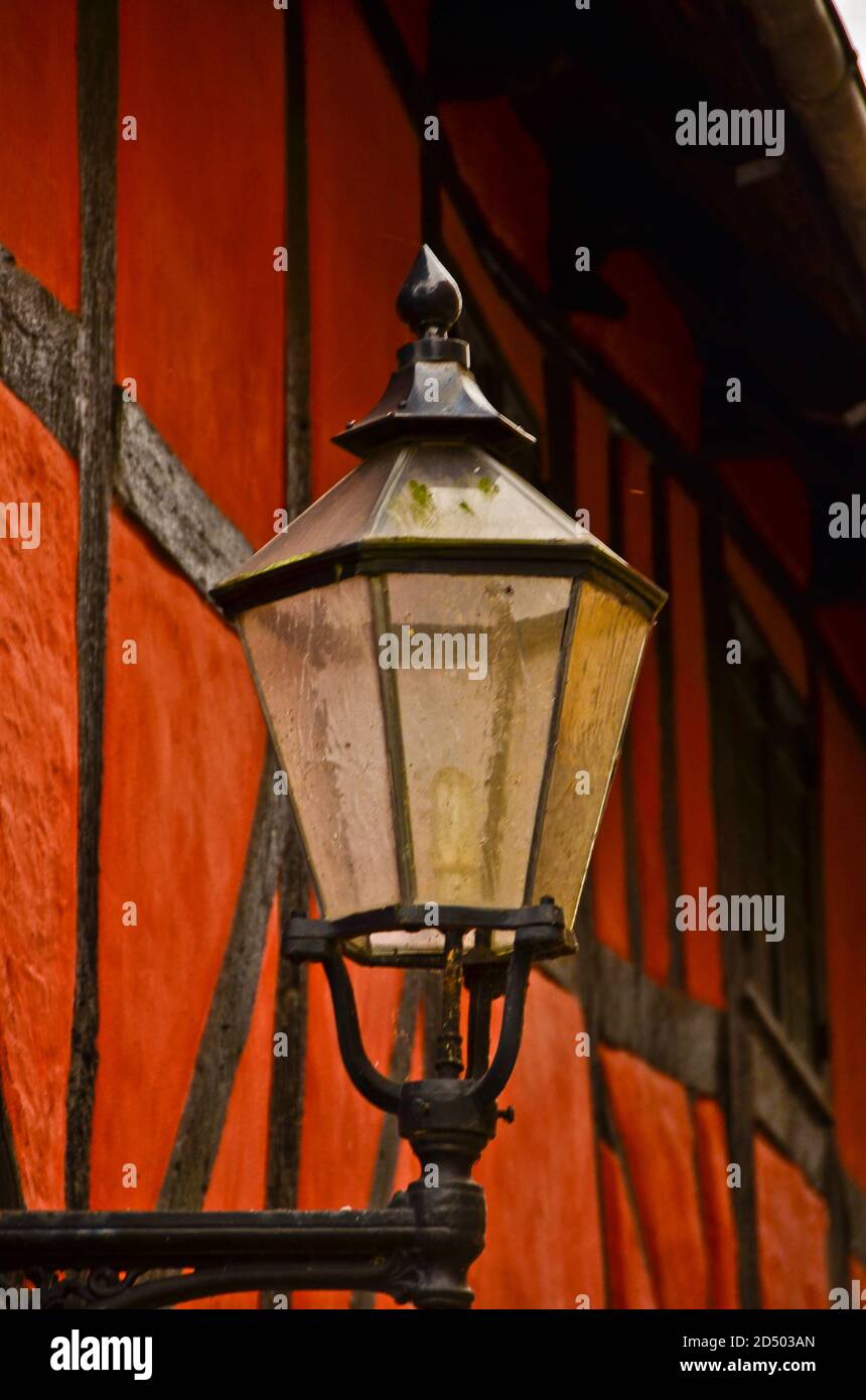 A medieval red frame house with an old fashioned lantern in a small ...