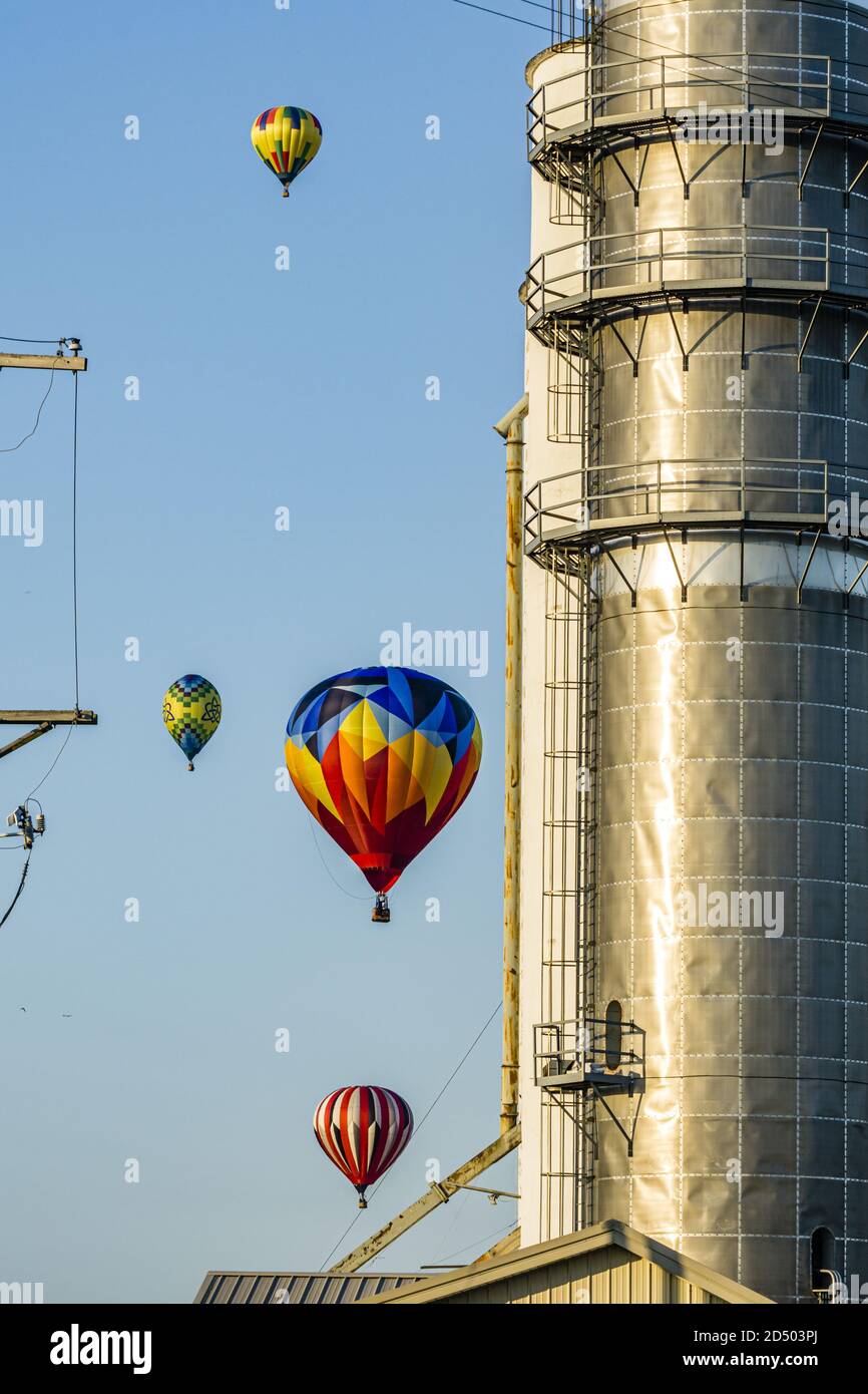 Four colorful hot air balloons dramatically fly near power lines and ...