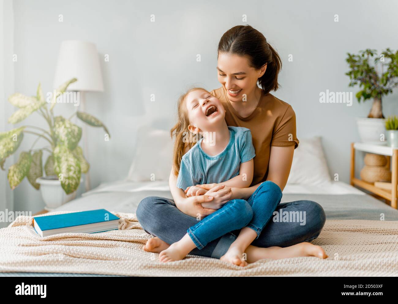 A nice baby girl and her mother enjoy sunny morning. Good time at home ...