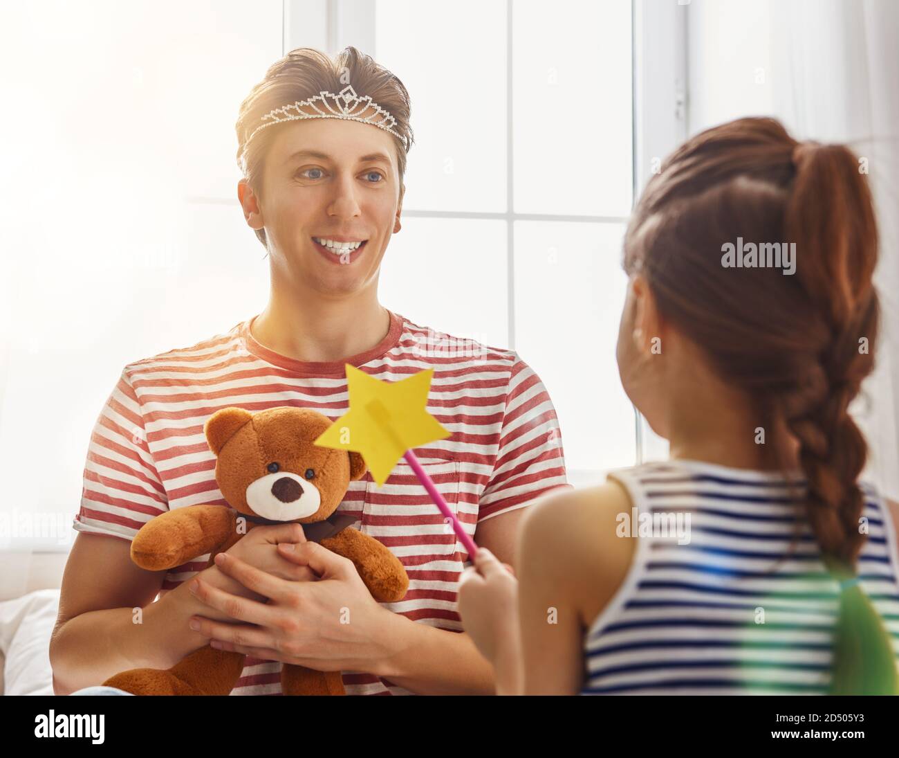 Funny time! Father and his child are playing at home. Cute girl holding ...