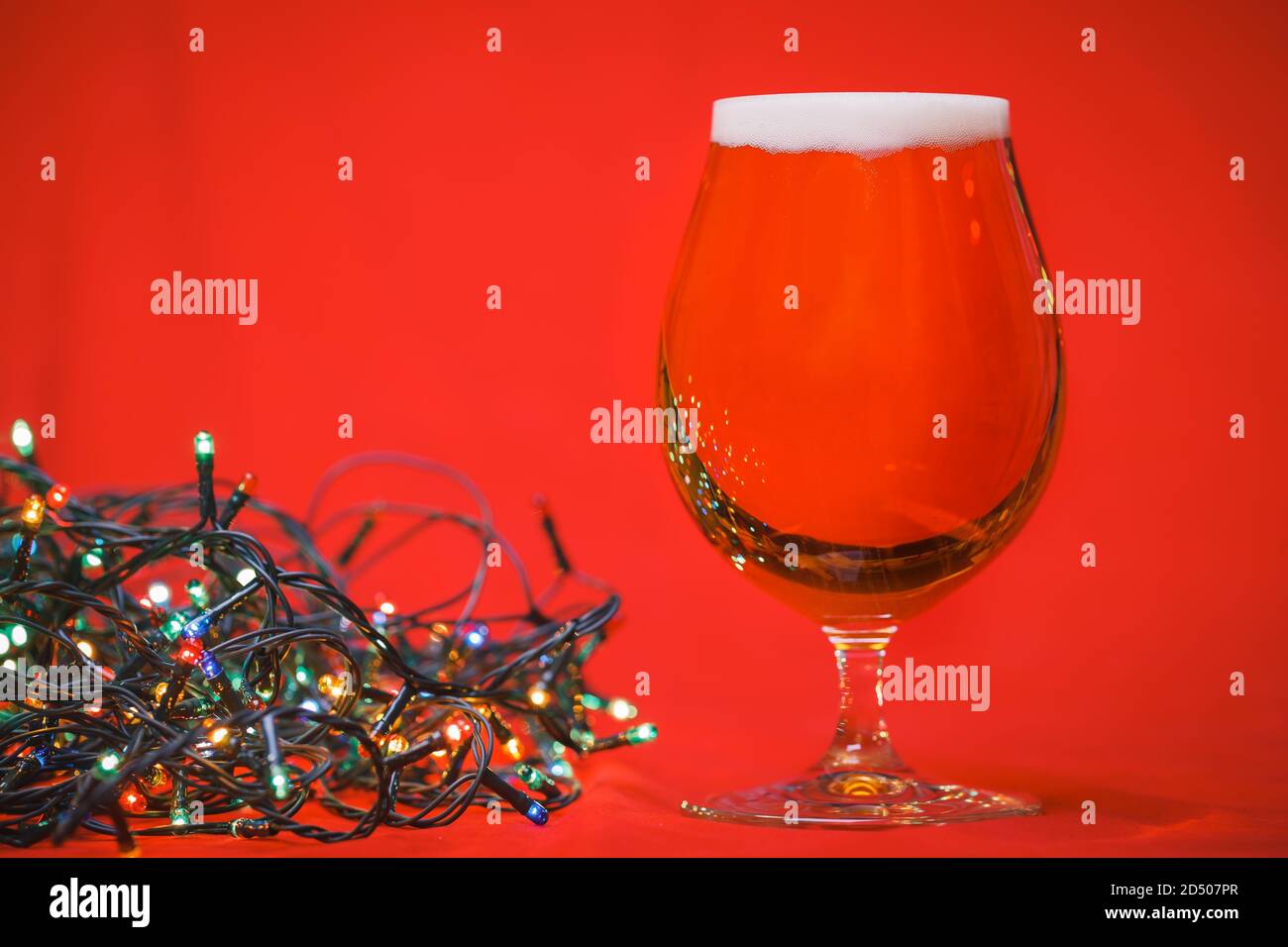 Full snifter glass of lager of pilsner beer with christmas lights on ...