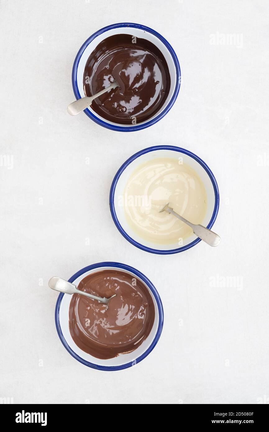 Three types of melted chocolate in bowls. Dark chocolate, milk ...