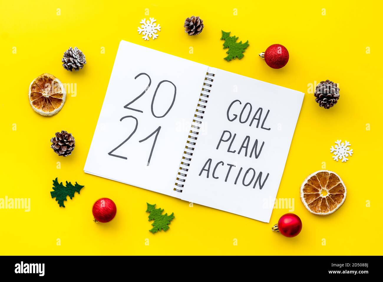Top view of 2021 goals list with decorations and notebook on a table ...