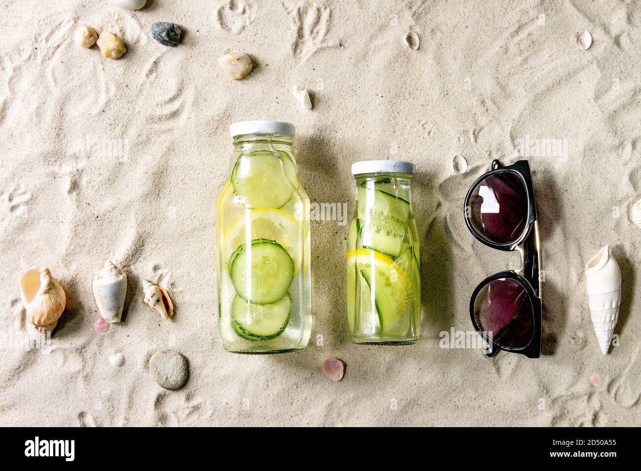 Summer theme. Two glass bottles with lemon and cucumber infusion sassy ...