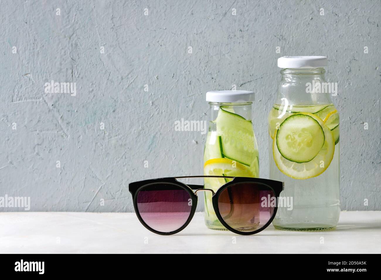 Summer drinks theme. Two glass bottles with lemon and cucumber infusion ...
