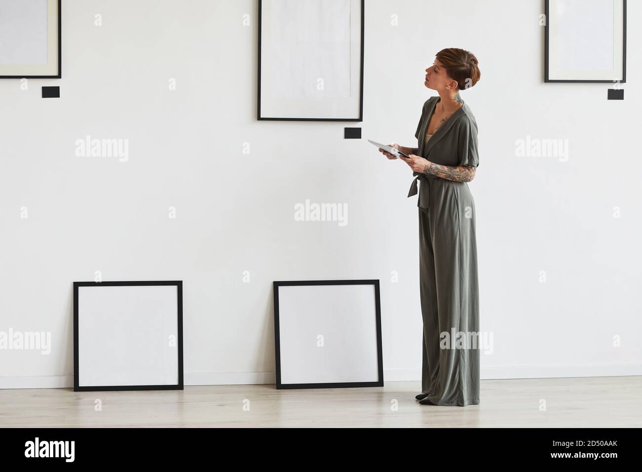 Graphic full length portrait of elegant female art gallery manager ...
