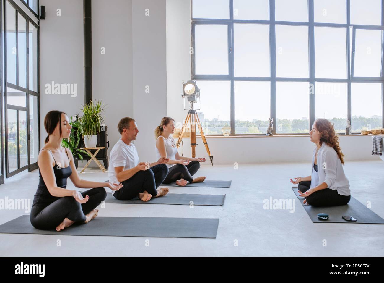 Yoga class of young people group indoor Stock Photo - Alamy