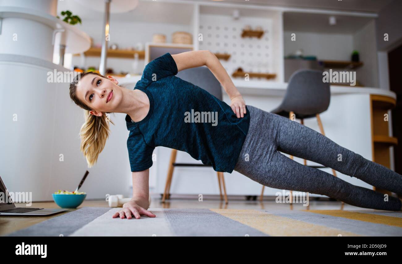 Beautiful young woman doing fitness exercise at home Stock Photo - Alamy