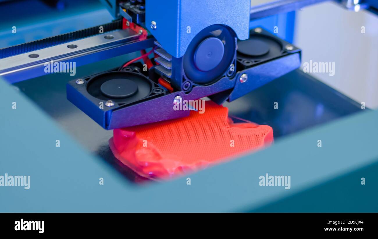 Three dimensional printing machine printing red 3D plastic model at ...
