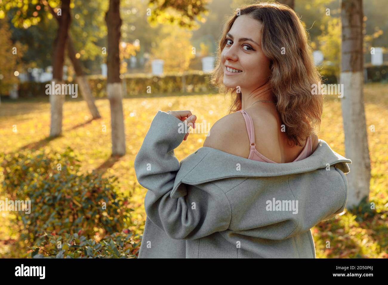 A beautiful young woman turns to look at the viewer from behind Stock ...