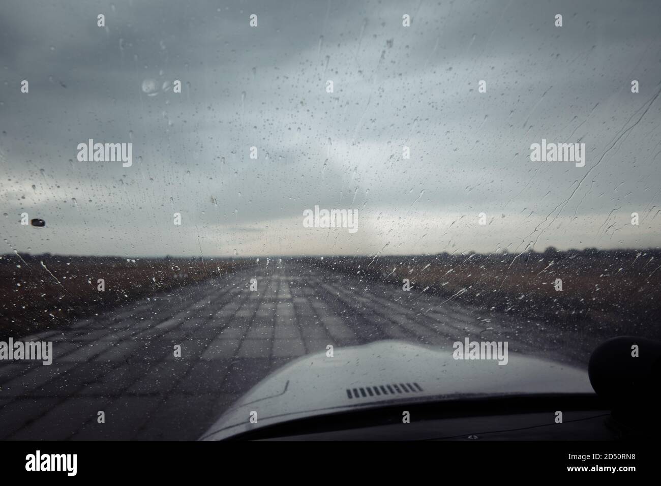 View from the cockpit on the runway in rainy weather Stock Photo - Alamy