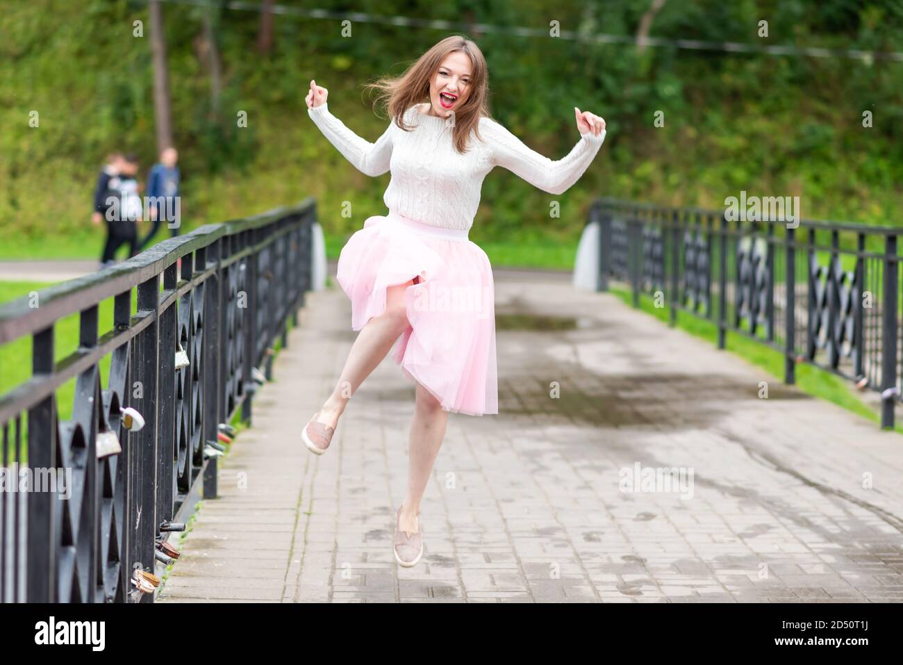 Girl jumping for joy on a bridge over the river Stock Photo - Alamy