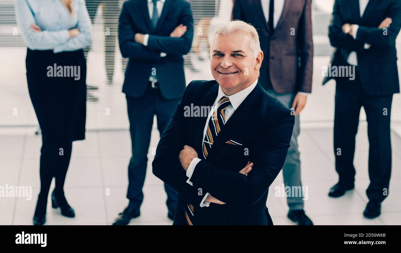 smiling boss and a group of different employees standing in the office ...