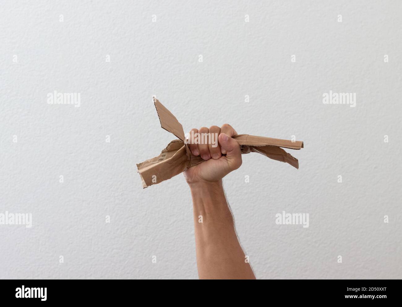 Hand squeezing cardboard or carton representing movement against ...
