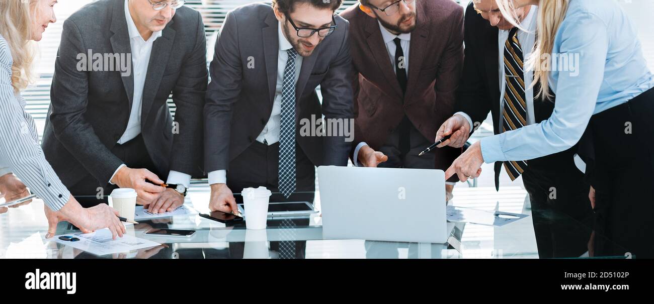 group of employees looking at the laptop screen with interest Stock ...