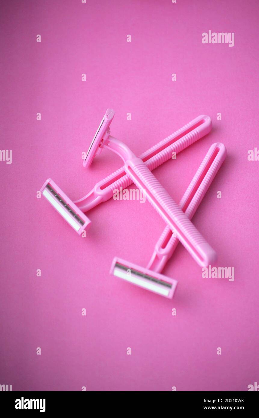 Isolated tree pink plastic female razors for single use on a same pink ...