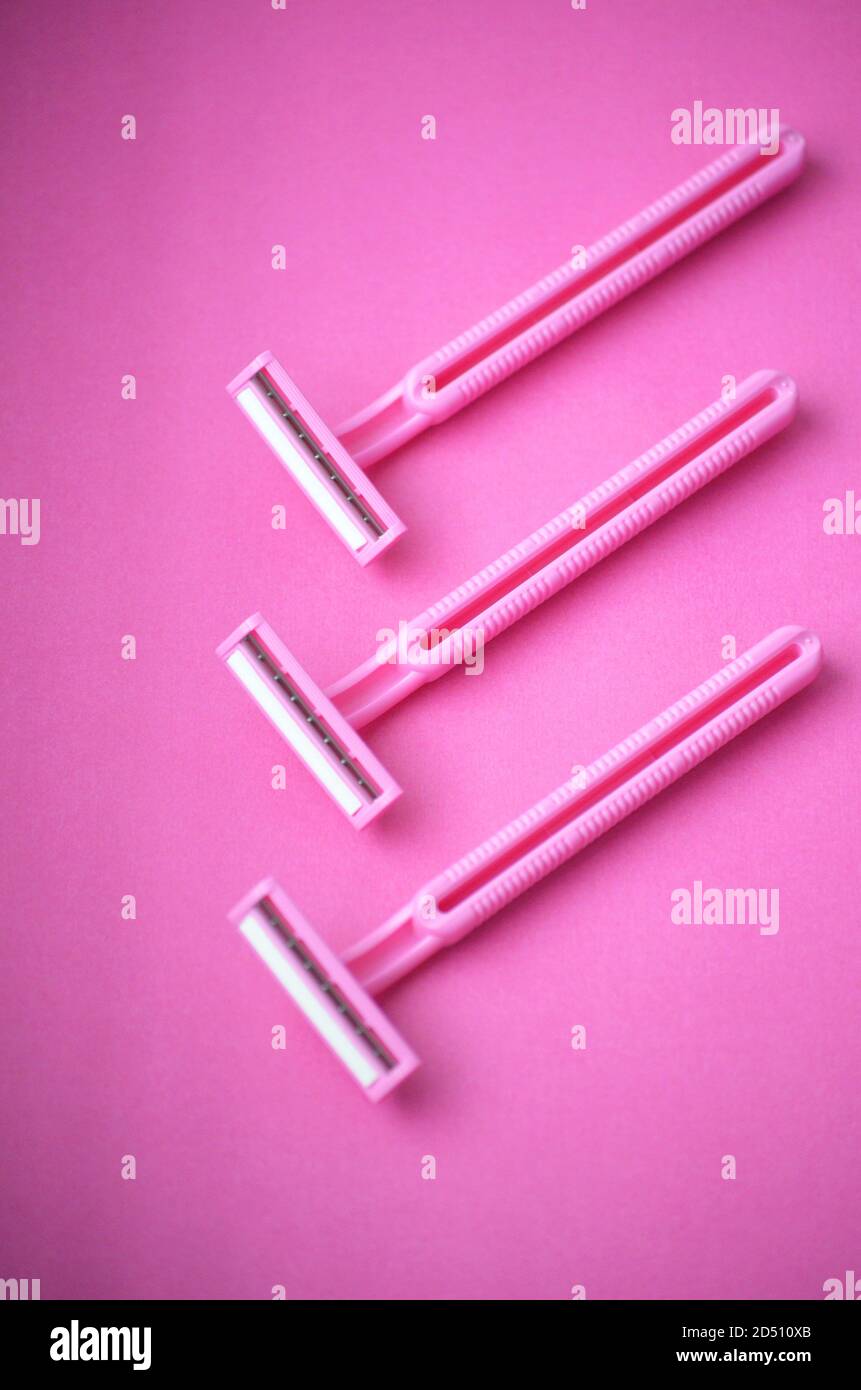 Isolated tree pink plastic female razors for single use on a same pink ...