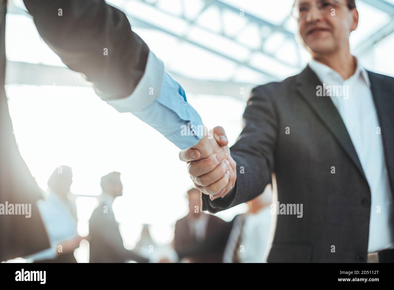 close up. strong handshake of business people on the office background ...