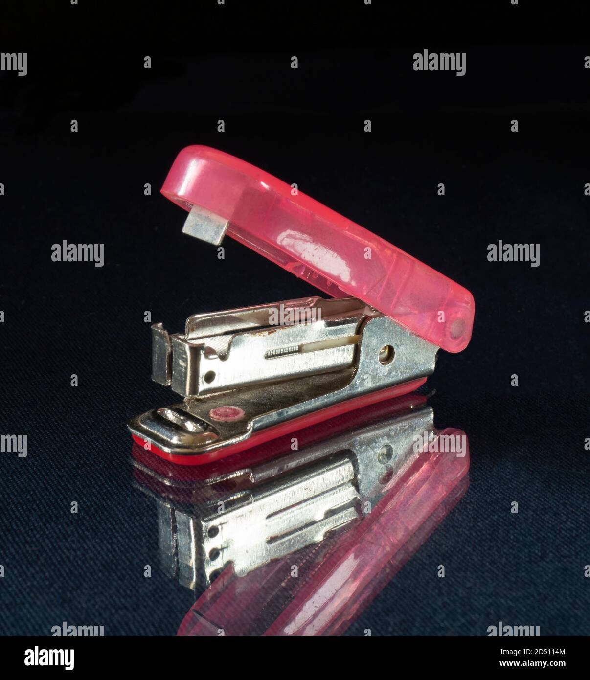 Stepler on table with reflection on black background. Instrument for ...