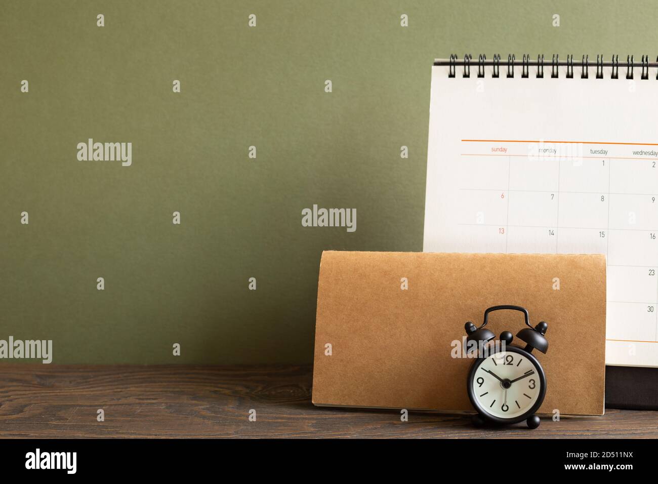 Calendar and alarm clock on desk with khaki background. Business ...