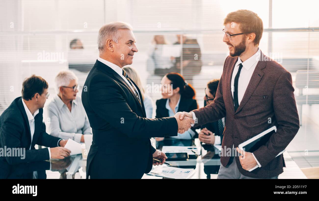 boss shaking hands with an employee near the desktop Stock Photo - Alamy