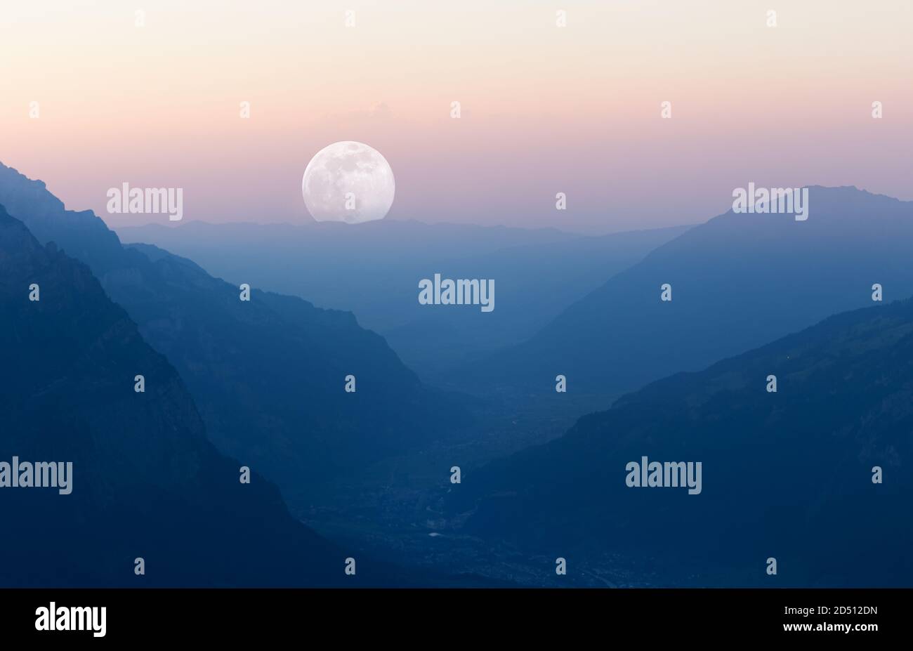Sunset with layered mountain landscape and moon at end of valley Stock ...