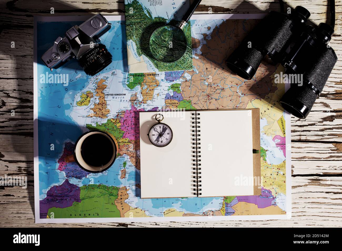 Flat lay of the travel planning concept. Top view of a diary, binoculars, compass, retro photo ...