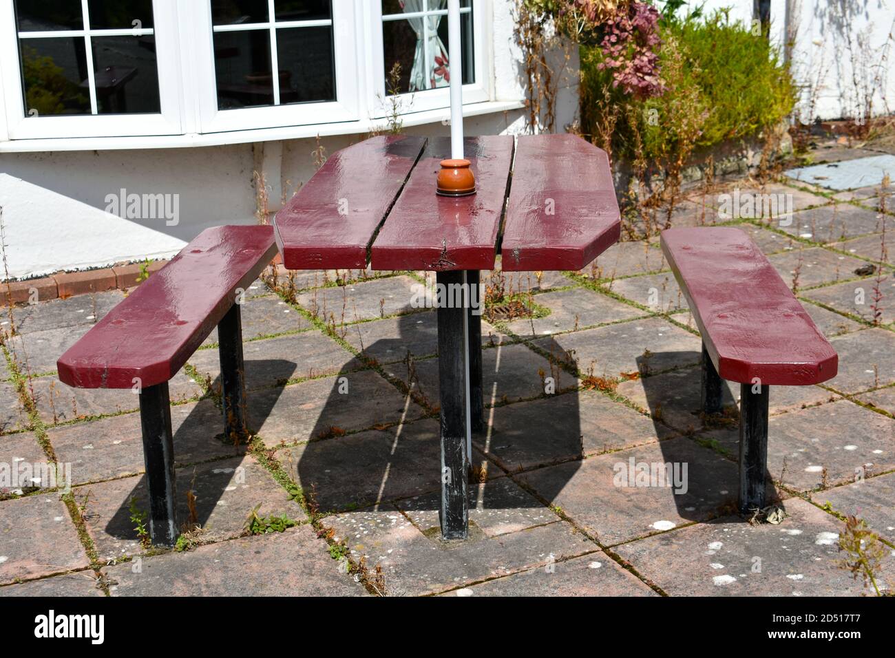 close up of red painted empty table and bench at outside restaurant ...