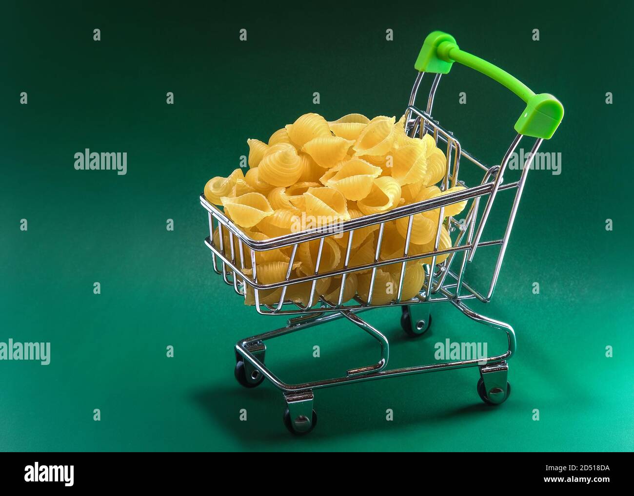 Pasta in the shape of seashells, mini supermarket cart filled to the ...