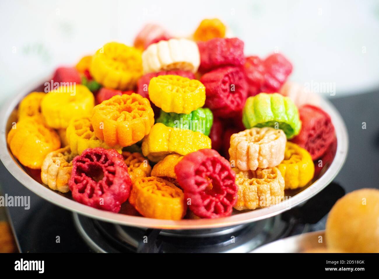 shot of colorful Fryums being deep fried in hot oil bubbling and ...
