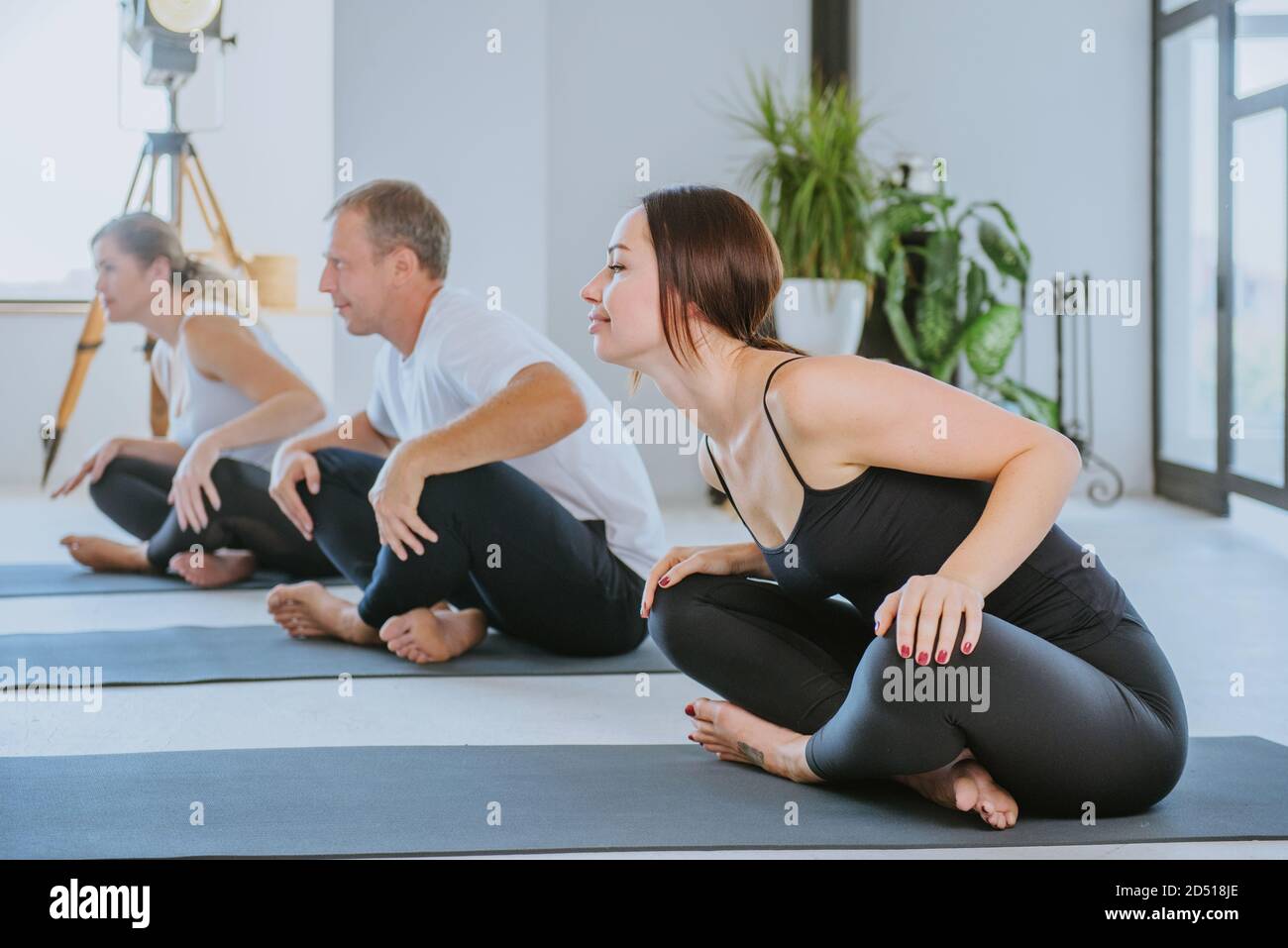 Yoga class of young people group indoor Stock Photo - Alamy