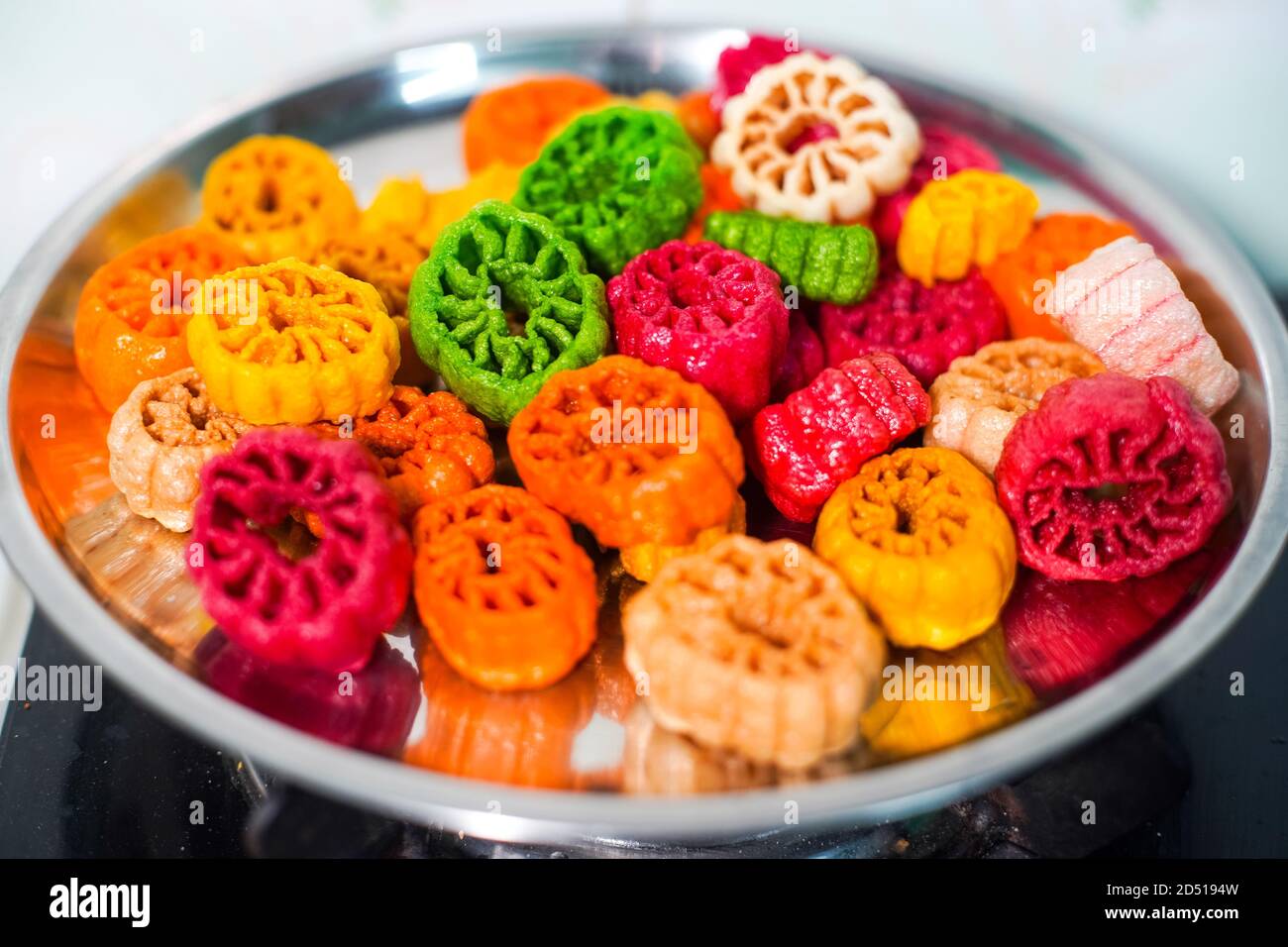 shot of colorful Fryums being deep fried in hot oil bubbling and ...