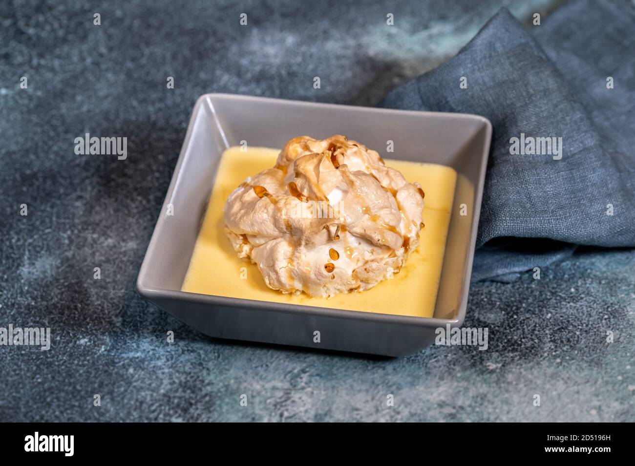 Floating island dessert made of meringue floating on vanilla custard ...