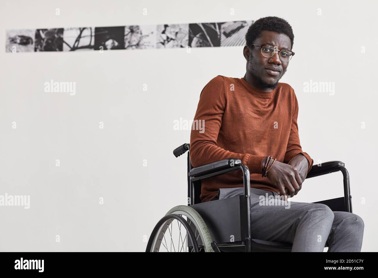 Minimal portrait of young African-American man using wheelchair and ...