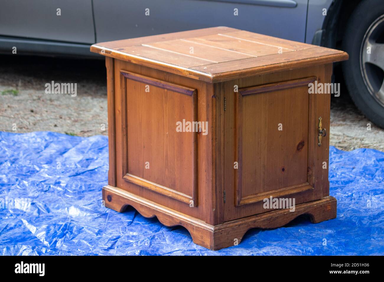 old antique side table set out on a blue tarp being refinished Stock ...