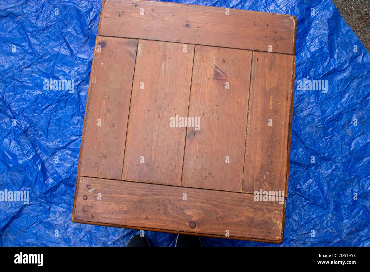 old antique side table set out on a blue tarp being refinished Stock ...