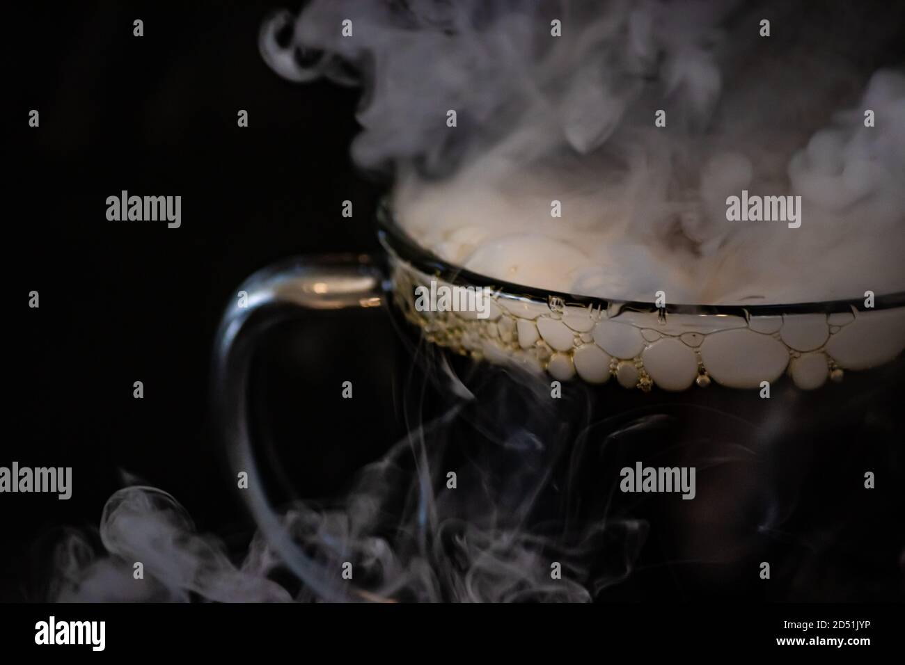 various glasses and dishes with water and dry ice smoking and bubbling ...