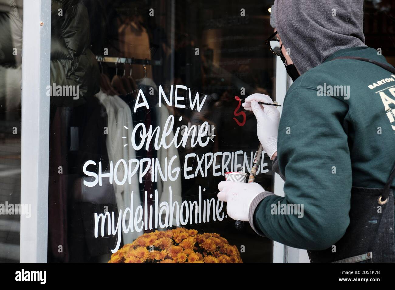 Artist painting old-fashioned hand-lettered window lettering sign on ...